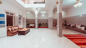 Uma sala de estar ampla com teto alto, varanda e paredes com padrão.