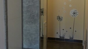 Um corredor com piso de azulejos, um banco e arte nas paredes retratando flores e dentes-de-leão.