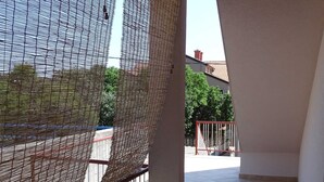 Varanda com vista para a rua e árvores.