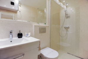 Suíte estúdio luxo, vista para o pátio | Banheiro | Secador de cabelo, toalhas de banho, papel higiênico