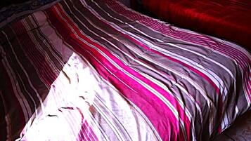 Uma cama com colcha listrada.