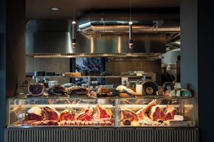 Vitrine com carnes e queijos diversos em um restaurante.