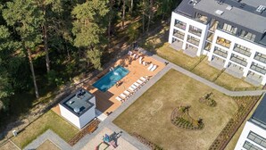 Vista aérea de uma área residencial com piscina, cadeiras de descanso e parquinho.