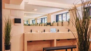 Uma casa de banho moderna com soalho de madeira, um banco e plantas em vasos.