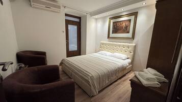Quarto com cama, cadeira, guarda-roupa e porta.