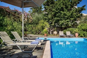 Piscina com espreguiçadeiras e pérgola.