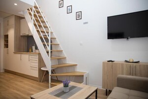 Apartamento Deluxe, vista para o pátio | Sala de estar | TV de ecrã plano, aparelhagem 