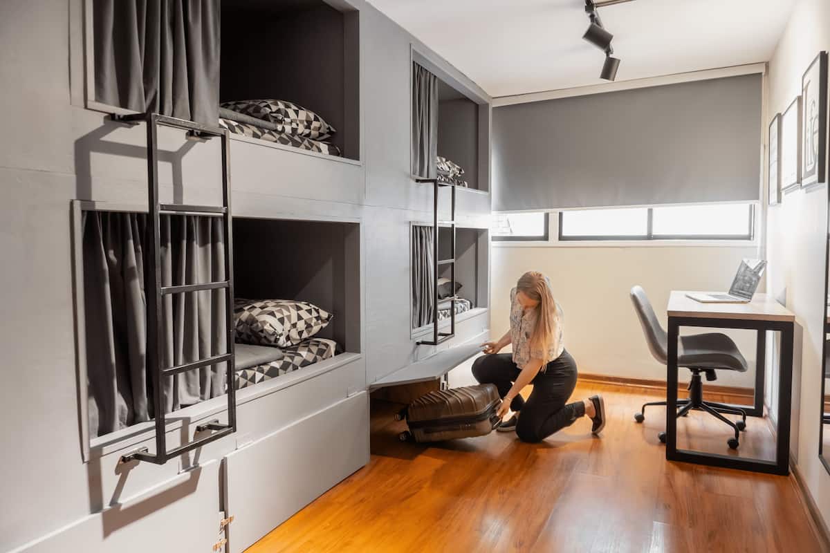 Quarto com beliches, uma escrivaninha e uma cadeira.