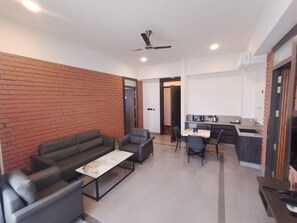 Apartamento família | Área de estar | TV de tela plana 32 polegadas com canais digitais