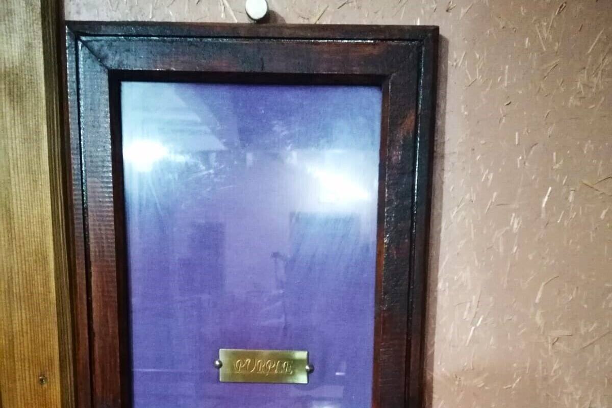 Espelho emoldurado com uma placa em uma parede com textura.
