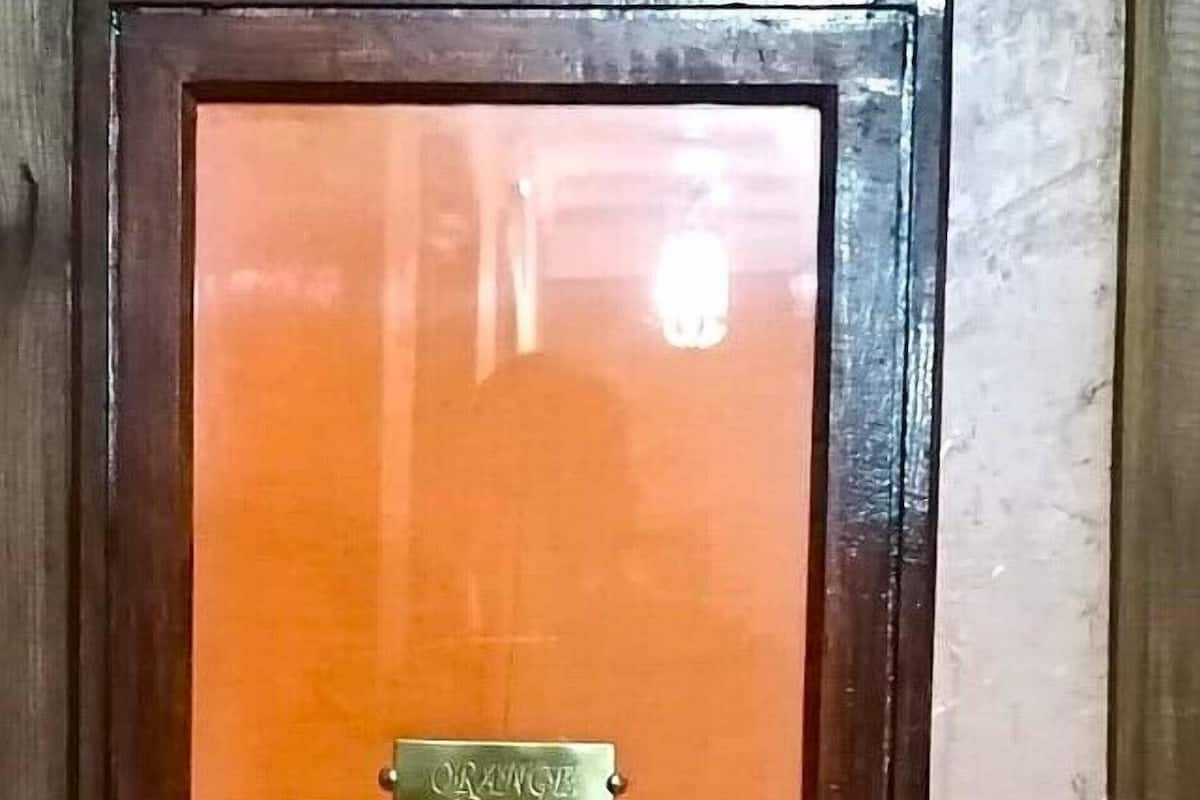 Uma porta com uma placa de latão que diz 'Orange'.