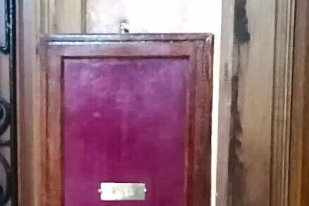 Uma porta com painel roxo e puxador de metal.
