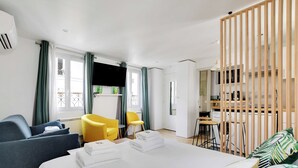 Quarto de hotel moderno com uma cama grande, um sofá, uma escrivaninha e uma cadeira.