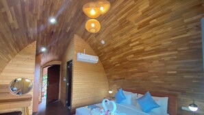 Um quarto acolhedor de madeira com uma cama, uma escrivaninha e uma cadeira.