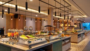 Disposição de buffet com diversos pontos de comida, incluindo frutas, legumes e bebidas.
