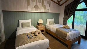 Quarto com duas camas de madeira, teto de madeira e uma janela grande.