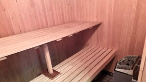 Sala de sauna com bancos de madeira e equipamento de sauna.