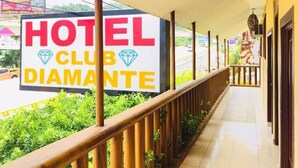 Um corredor de hotel com uma placa indicando "HOTEL CLUB DIAMANTE".