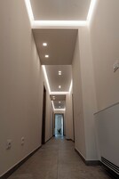 Um corredor moderno com iluminação embutida e piso ladrilhado.