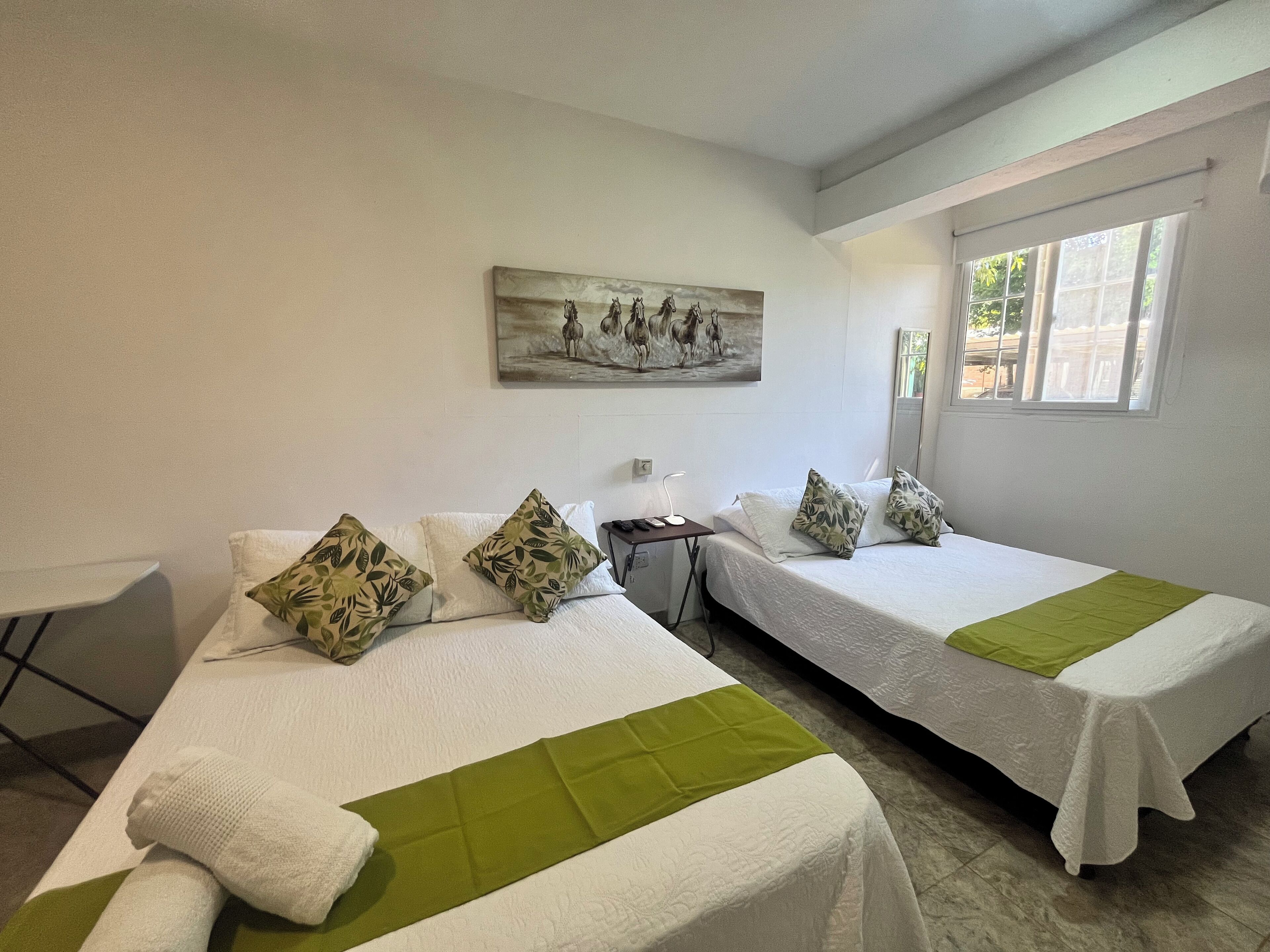 Quarto quádruplo exclusivo, 2 camas Queen, cozinha, vista para o pátio | Cofres nos quartos, Wi-Fi de cortesia, roupa de cama