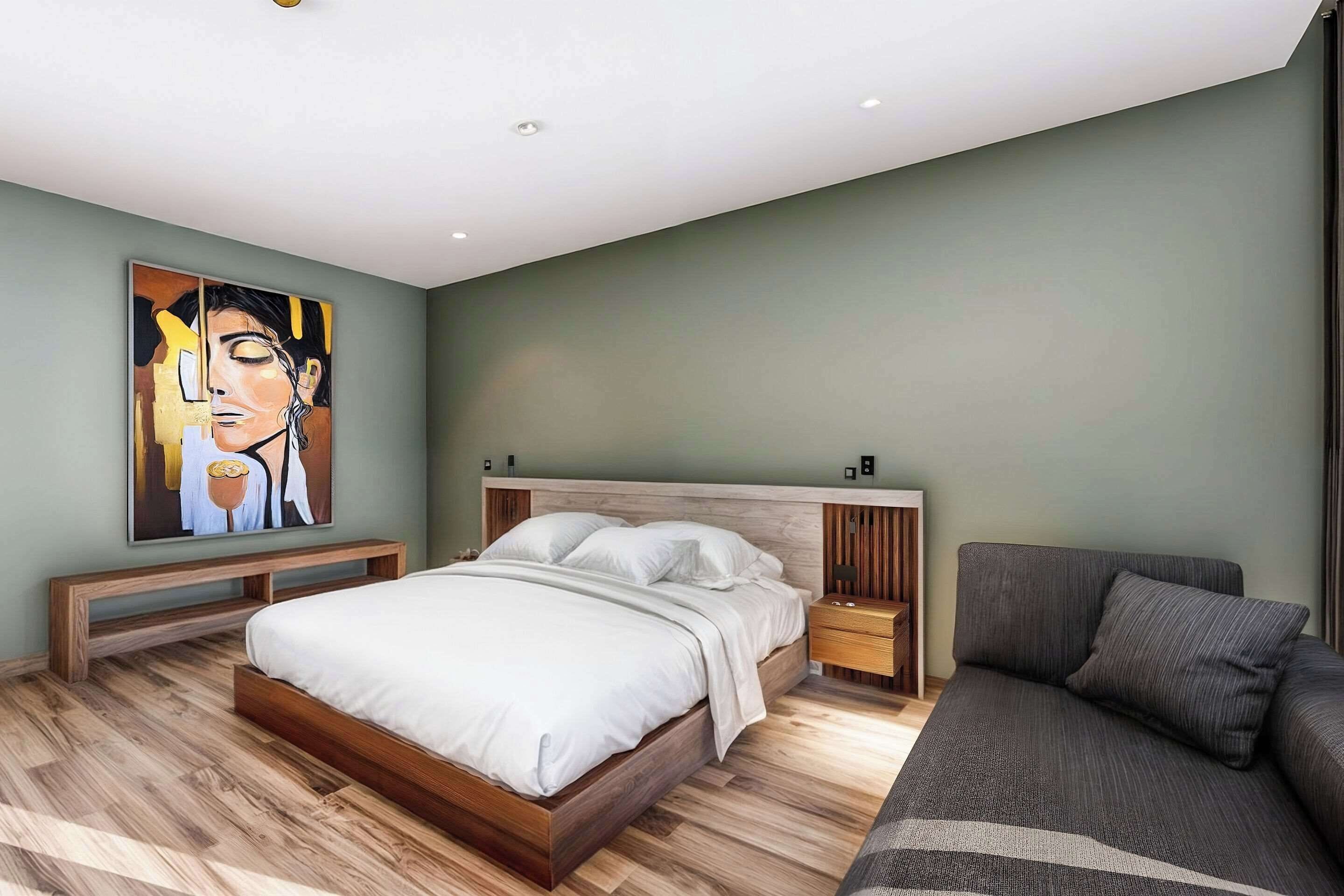Quarto moderno com uma cama de madeira, um sofá cinza e um quadro na parede.