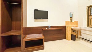 Uma casa de banho moderna com um lavatório de madeira, uma pia, um espelho e uma televisão montada na parede.