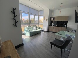 Apartamento, 1 cama Queen e sofá-cama (1 Bedroom) | Área de estar | TV 65 polegadas com canais a cabo