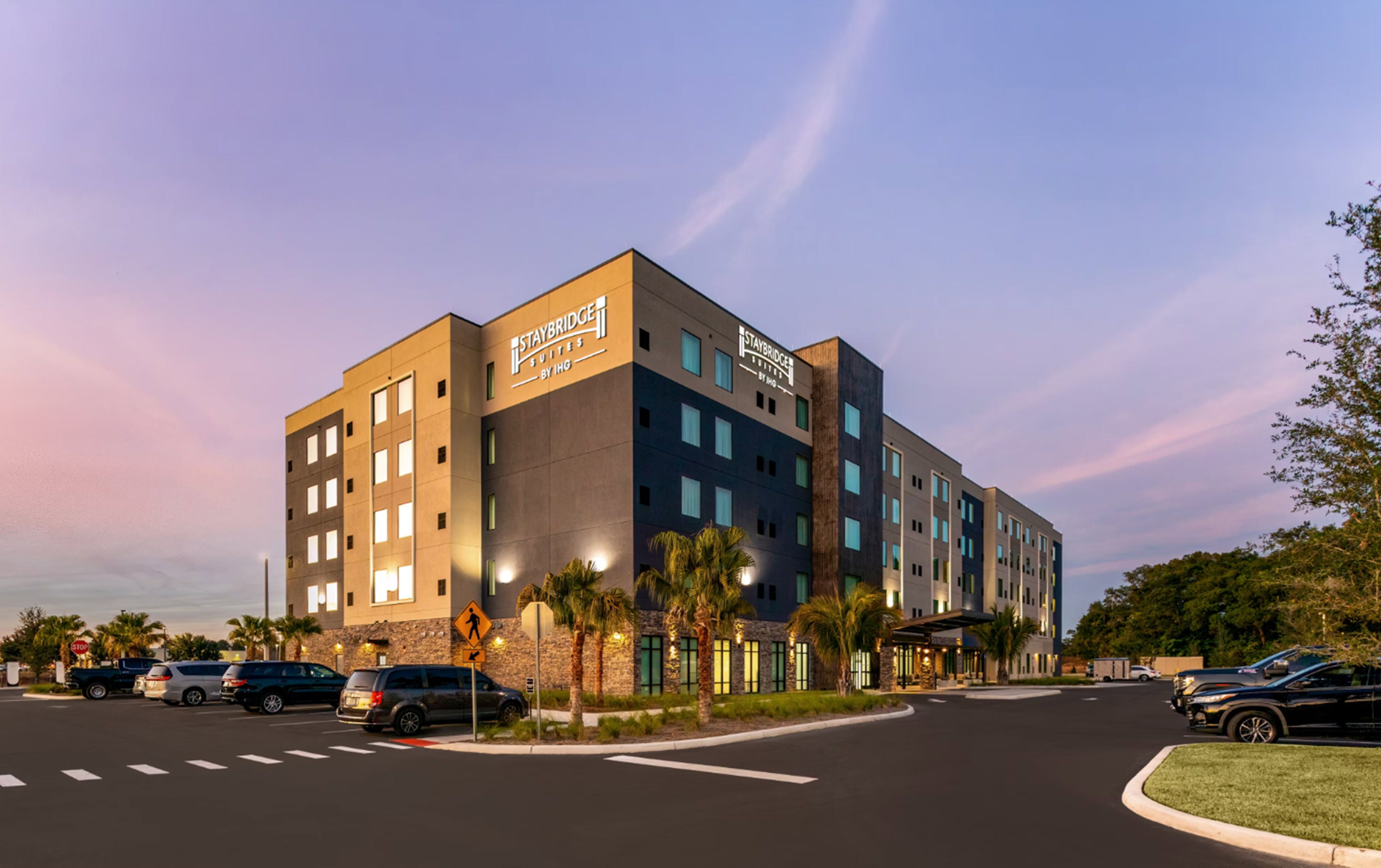 Um hotel Staybridge com design moderno, vários andares e área de estacionamento.
