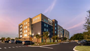 Um hotel Staybridge com design moderno, vários andares e área de estacionamento.
