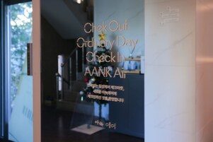 Uma área de recepção com uma árvore de Natal e uma placa que diz "Check Out Ordinary Day Check In AANK Air".
