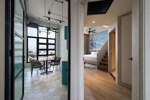 Um interior moderno com área de refeições, quarto com vista e escada.