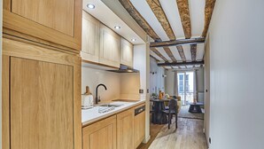 Cozinha moderna com armários de madeira, bancada branca e lava-louças embutida.