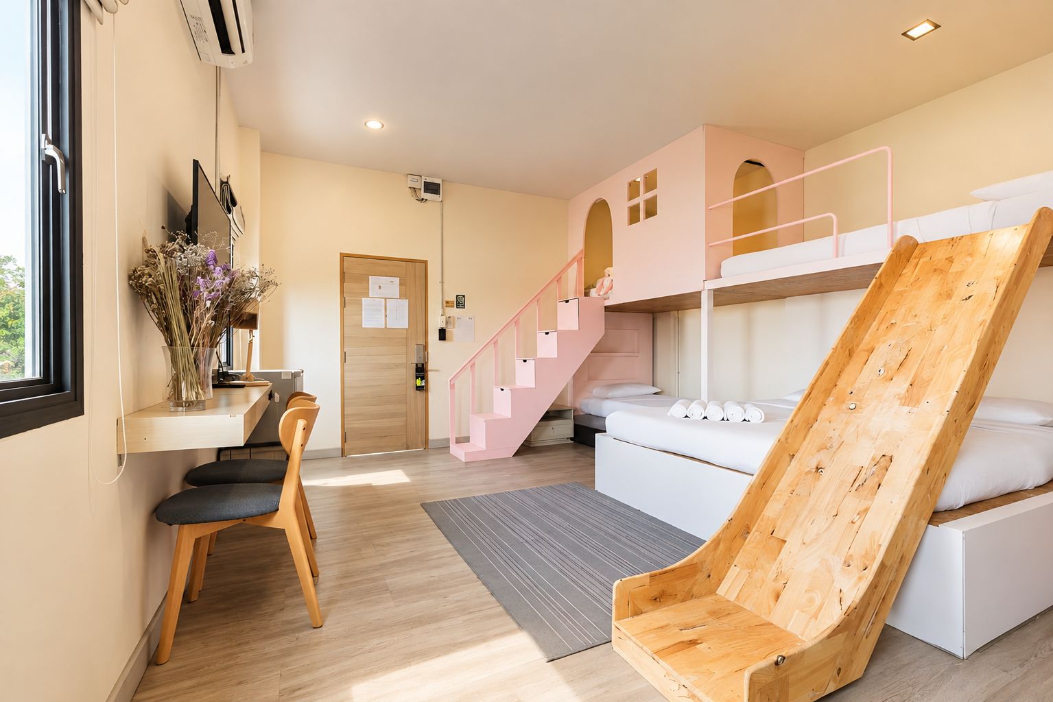 Quarto com beliche, escrivaninha com cadeira, escorrega de madeira e escada.