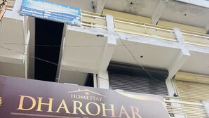 Um edifício com uma placa indicando "Dharohar" e quartos com ar condicionado disponíveis.