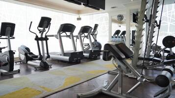 Uma academia com esteiras, elípticos e equipamentos de musculação.