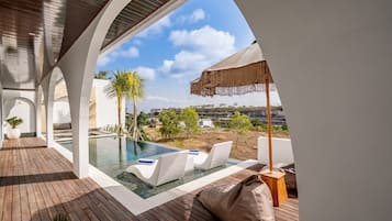 Uma área moderna de piscina exterior com vista ampla da paisagem circundante, incluindo um edifício distante e árvores.