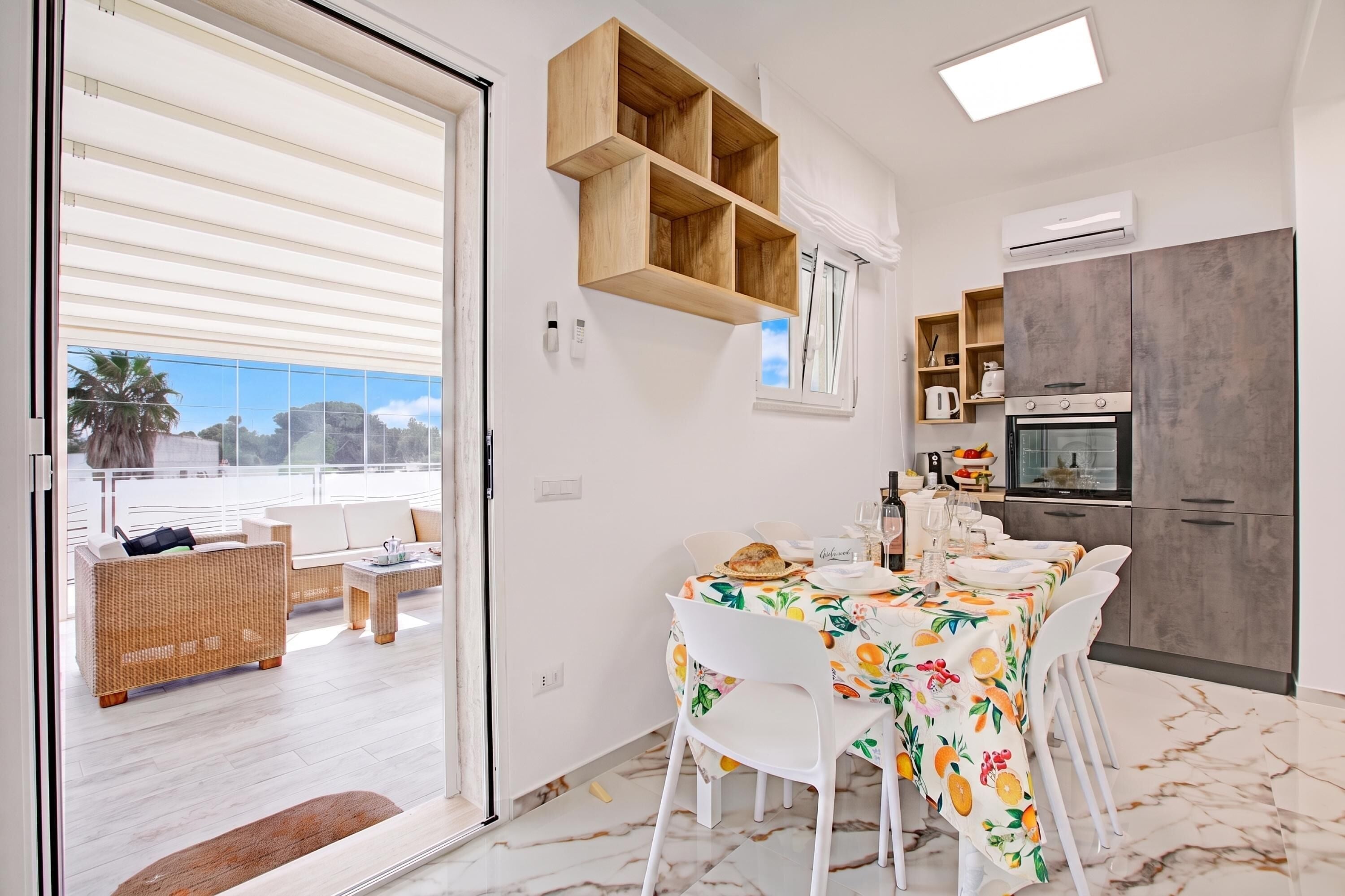 Uma cozinha moderna com forno embutido e um espaço de jantar com uma mesa posta para dois.