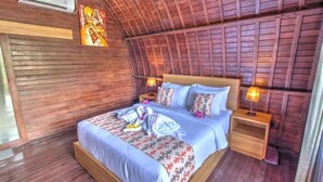Quarto de madeira com uma cama, mesas de cabeceira e ar condicionado fixado na parede.