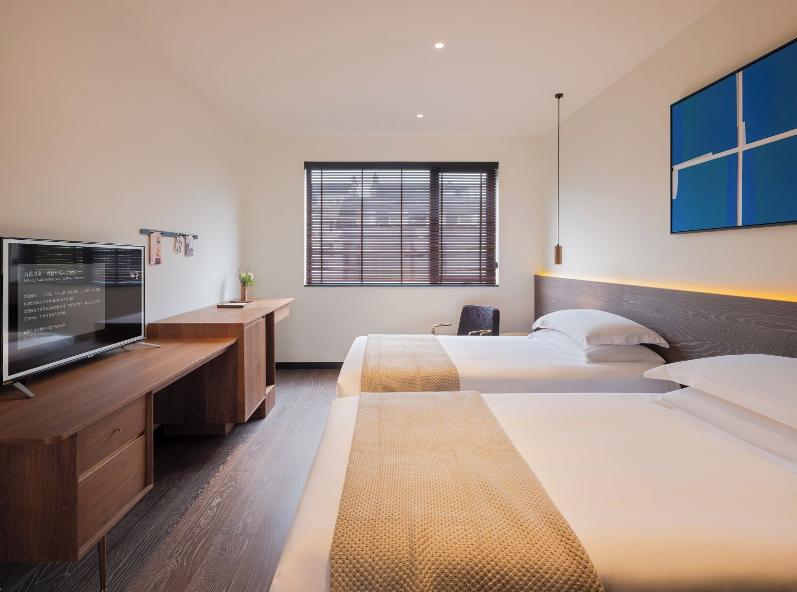 Quarto de hotel com uma cama, mesa de cabeceira e televisão.