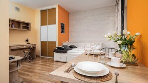 Quarto moderno com cama, mesa de cabeceira e vista para uma parede de tijolos.