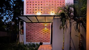 Um edifício moderno com fachada estampada e área de entrada coberta.
