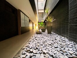 Um corredor com chão de azulejos, plantas em vasos e design de interiores moderno.