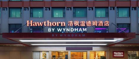Um hotel chamado Hawthorn by Wyndham com fachada moderna e grandes janelas.