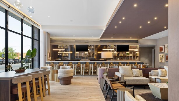 Um interior moderno com área de bar, assentos e cozinha.
