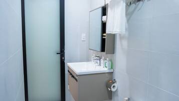 Um banheiro moderno com vaso sanitário, pia e porta-toalhas.