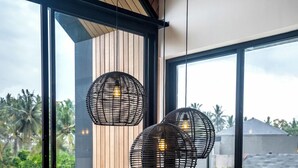 Um interior moderno com grandes janelas, um banco de madeira e um apoio de cabeça decorativo em formato de animal.