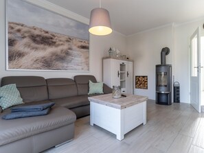 A living room with a sofa, a coffee table, a cabinet, a fireplace, and a painting on the wall.
