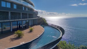 Um hotel moderno com piscina e vista para o oceano.