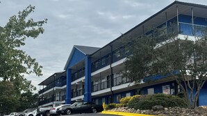 Um edifício de vários andares com fachada azul e telhado plano.