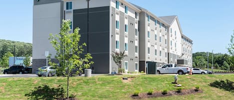 Um hotel de vários andares com telhado plano e uma placa com a inscrição 'Woodspring Suites'.
